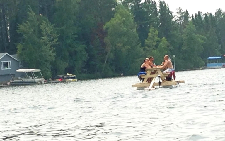 Picnic table floating on lake like a luxury party barge - Homecrux
