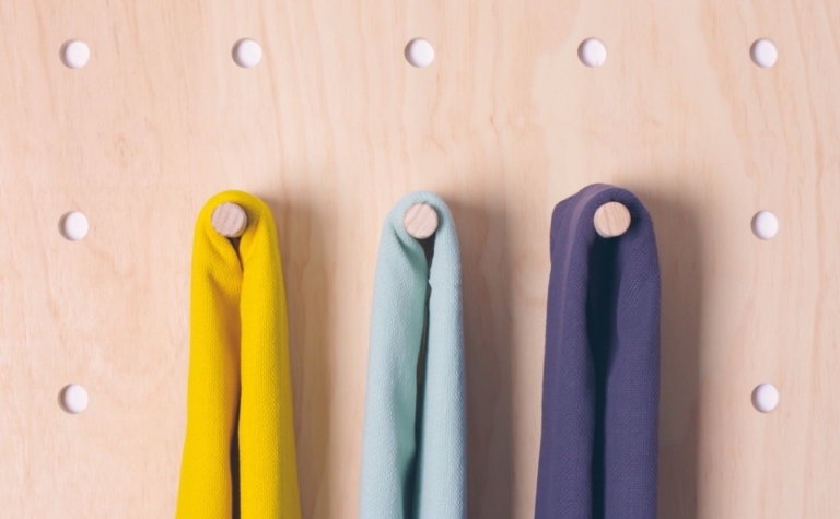 Modular shelving unit uses pegs to support shelves and hang clothes ...