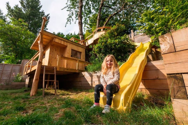 Dad Builds Garden Treehouse with Slides For His Daughters