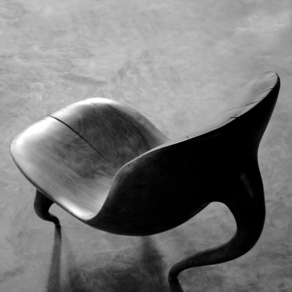 This Curvy Wooden Chair Sits on Two Legs and A Ponytail