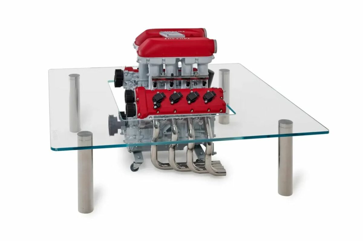 A Coffee Table With Ferrari V8 Engine Piercing Through its Top