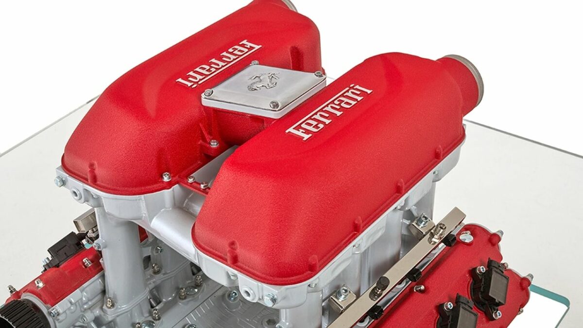 A Coffee Table With Ferrari V8 Engine Piercing Through its Top