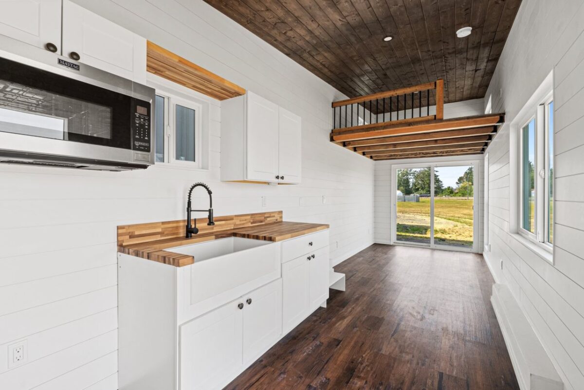 Frontier Tiny House Features a Bedroom with a Sliding Glass Door