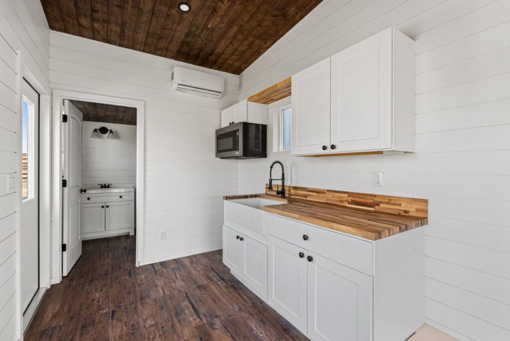 Frontier Tiny House Features a Bedroom with a Sliding Glass Door