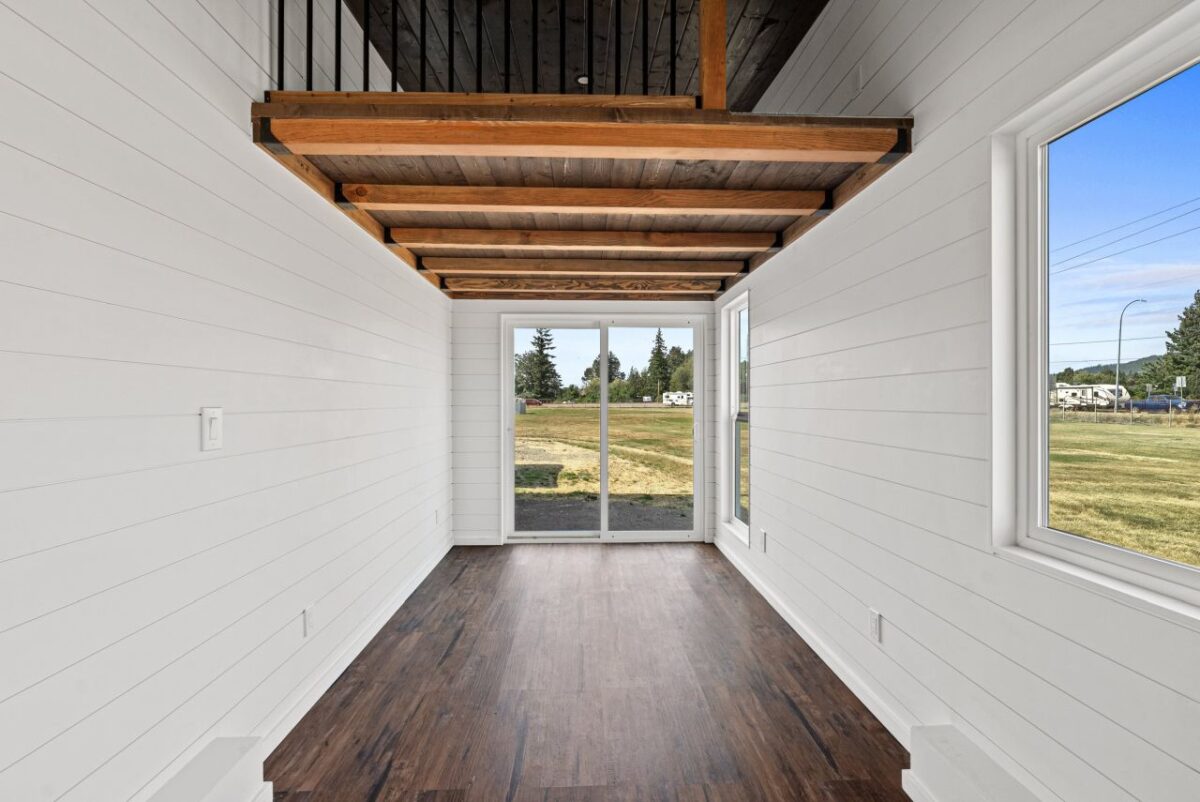 Frontier Tiny House Features a Bedroom with a Sliding Glass Door
