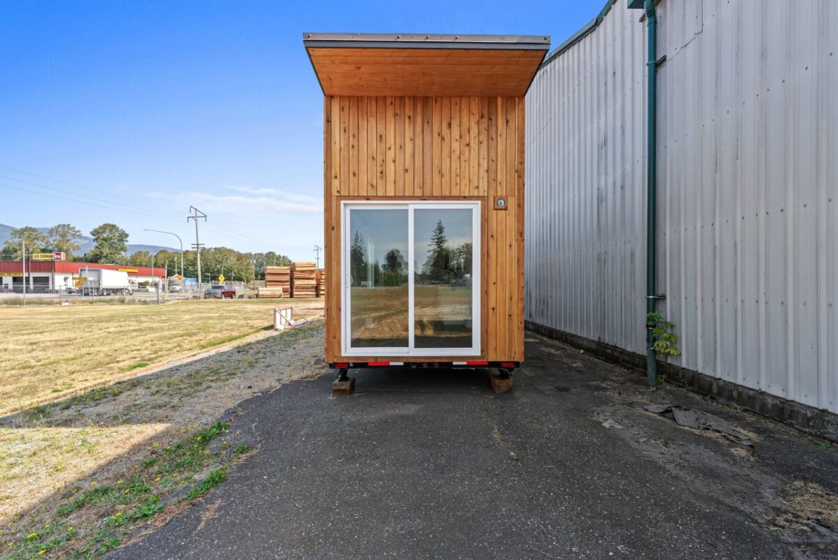 Frontier Tiny House Features a Bedroom with a Sliding Glass Door