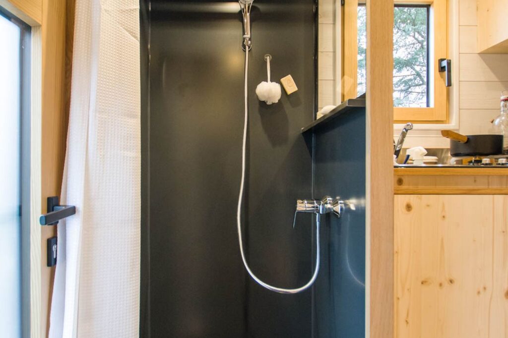 Bonzai Tiny Home Features a Futon, Projector, & Pull-Down Screen